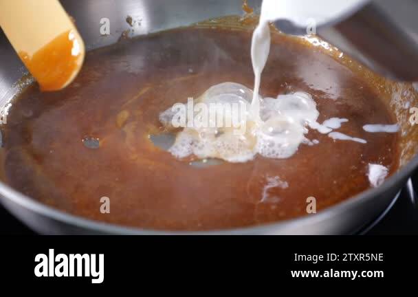 Caramelizing sugar on a pan. Boiling caramel syrup on stove in pot pan ...