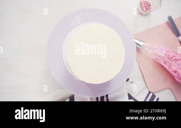 Step by step. Flat lay. Icing tall birthday cake with white buttercream ...