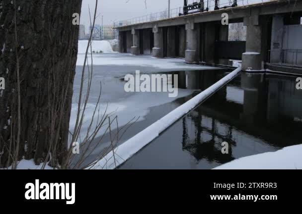River, dam with winter scene in background. The turbulent water of the ...