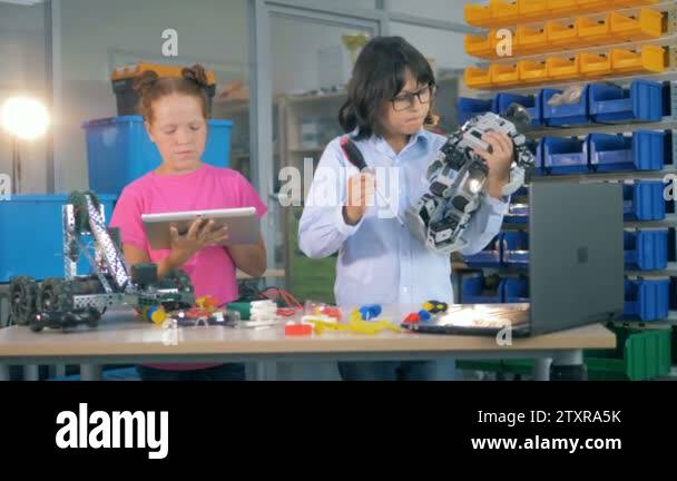 Two kids fixing a robot in a laboratory. Innovative technical education ...