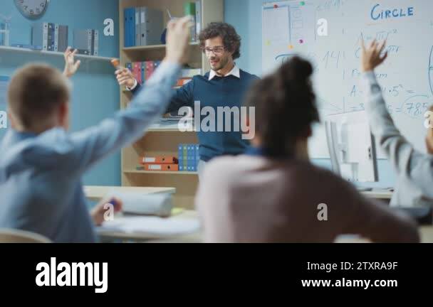 Teacher Explains Lesson to a Diverse Classroom of Bright Children. In ...