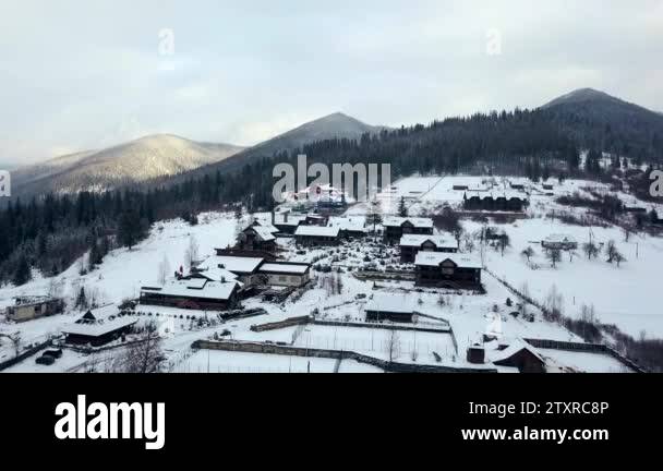 Aerial of inhabited locality in the mountains on winter. Mountain ...