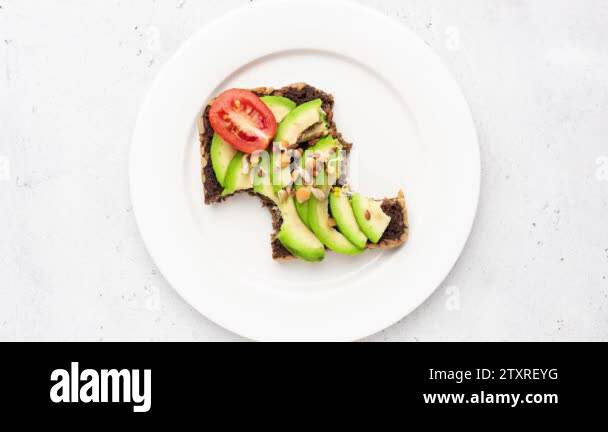 Stop motion animation of eating vegan food avocado toast bite by bite ...