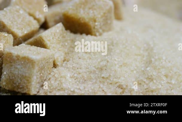 A macro shot of a composition of sugar cane, sugar cubes and sugar in ...