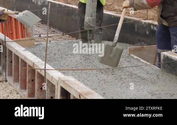 Pouring concrete mix from cement mixer on concreting formwork. Finished ...