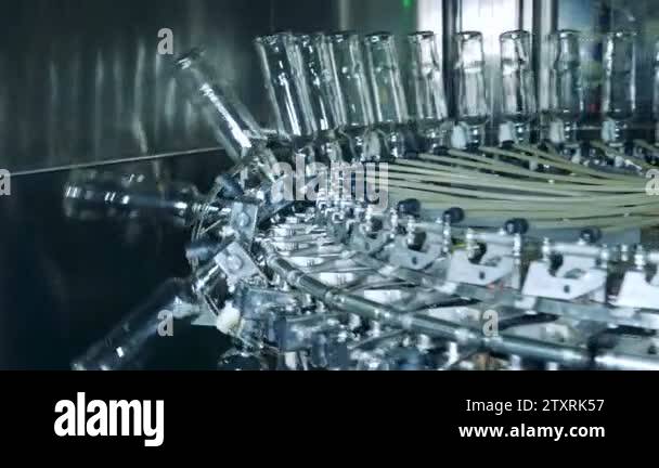 Glass bottles are getting lowered by a factory mechanism. 4K Stock ...