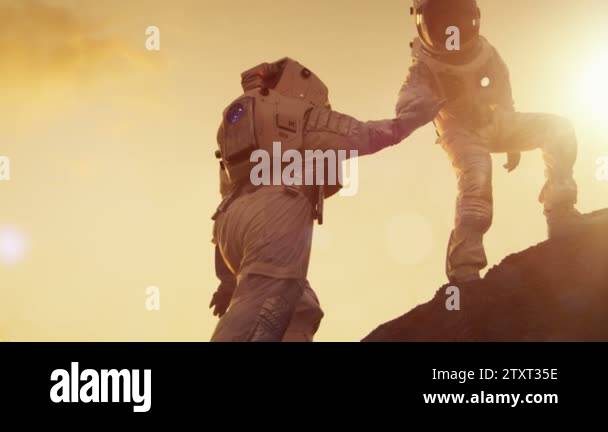 Two Astronauts Climbing Mountain Hill Helping Each Other, Reaching the ...