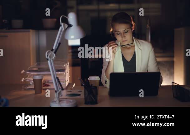 Beautiful girl in formal clothing in working on laptop alone in dark ...