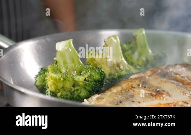 Fire, flame and oil splashes in slow motion while cooking fish fillet ...