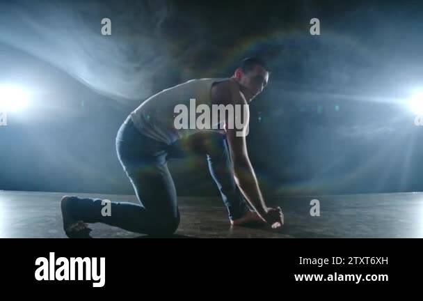 Modern ballet, a man from a sitting position on the stage jumps ...