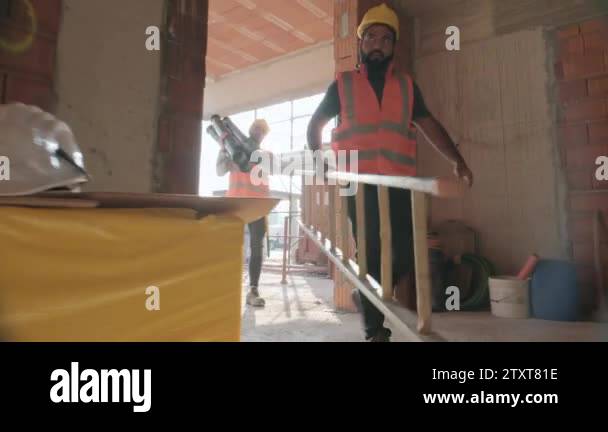 People working in construction site. Men at work in new house inside ...