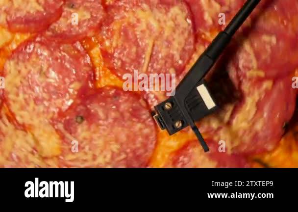 Pizza pepperoni rotating on turntable vinyl player. Concept of party ...