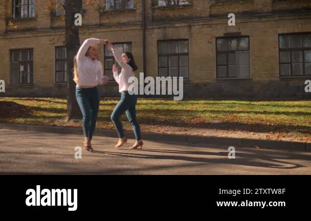 Two Awesome Caucasian Girls Are Dancing Together On The Street In Sunny ...