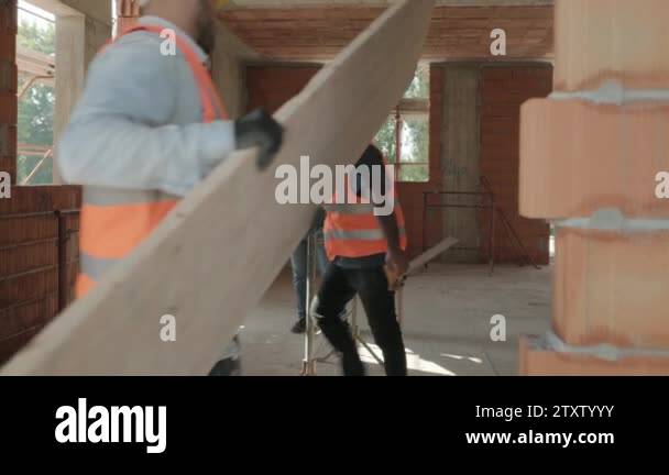 People working in construction site. Men at work in new house inside ...