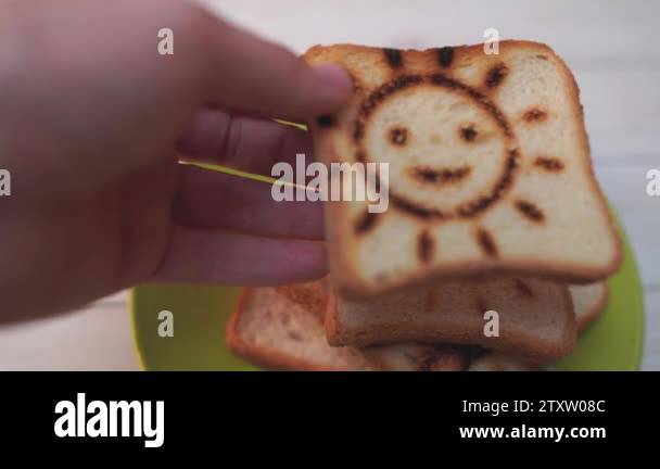 Detail of male hands spreading butter over a toasted bread slice ...