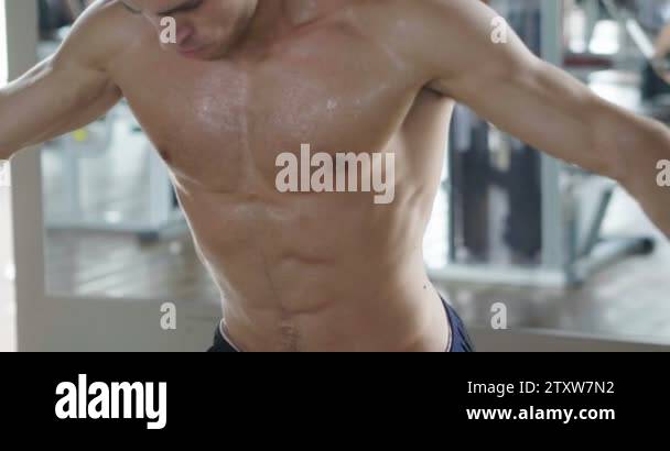 A shirtless guy at the gym, trains his body to stay fit and have ...