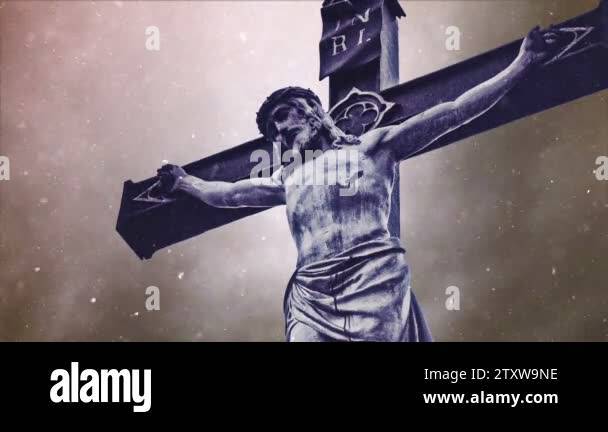 Crucifixion cross with Jesus Christ statue over stormy clouds and Snow falling time lapse as ...