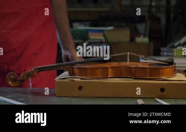 The professional violin master makes a violin with his own hands, uses ...
