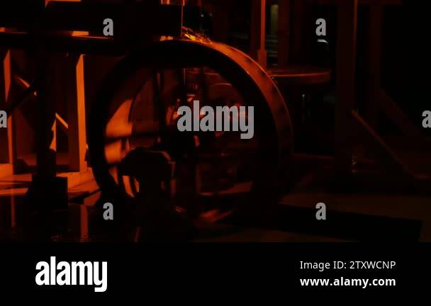 Water flow moving a wooden wheel of an old mill model in a dark ...