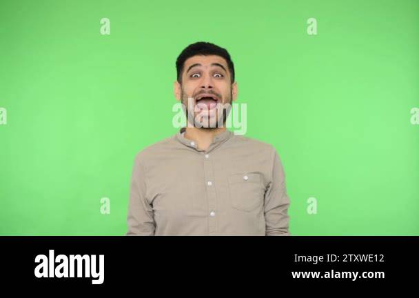 Funny carefree brunette man with bristle in shirt sticking out tongue ...