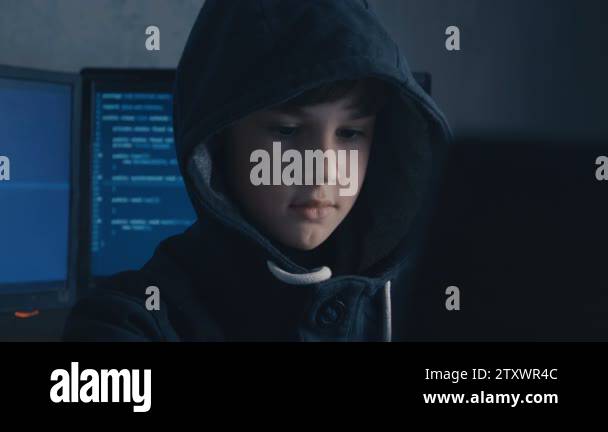 Portrait of a Genius Boy Hacker Prodigy in the hood working on computer ...