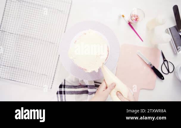 Step by step. Flat lay. Icing tall birthday cake with white buttercream ...