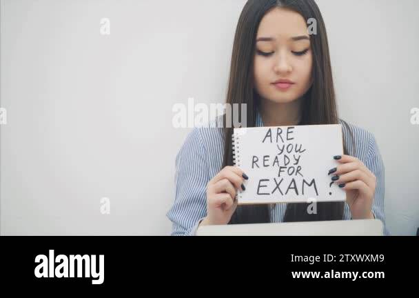 Lovely young asian lady sitting, with laptop, raising a sheet of paper ...