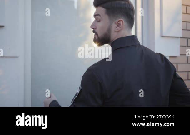 Male Caucasian police officer with brown eyes and black hair knocking ...