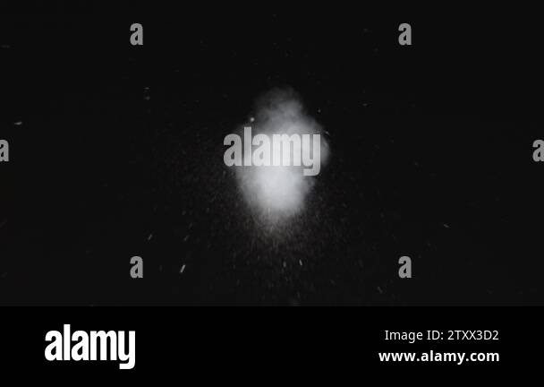 Dusty bullet hit on a wall with chunks of debris flying out. White ...