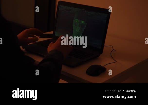 Hacker typing code in a dark room and creating artificial intelligence ...