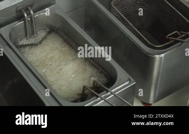 vegetable oil boils in restaurant Deep fryer, French fries cooking in ...