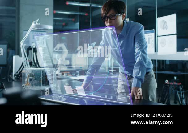 Asian High Tech Engineer Uses Modern Computer With Transparent Holographic Display. Monitor ...