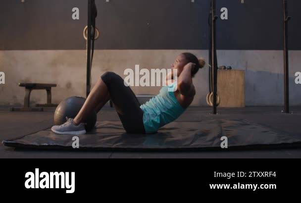 Side view of an athletic mixed race woman wearing sports clothes cross ...