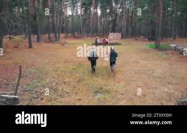 Four men knightes running on each other in the forest in full armour ...