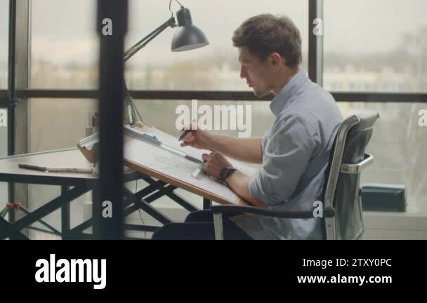 architect man Standing working with blueprints sketching a construction ...