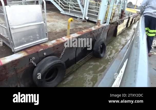 Man moor barge. The sailor ties the mooring rope of the ferry to a ...