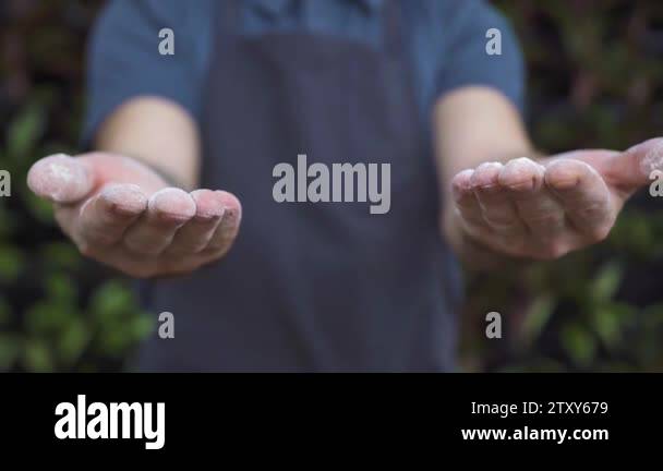Close up baker clapping hands with flour in bakery shop. Chef clapping ...