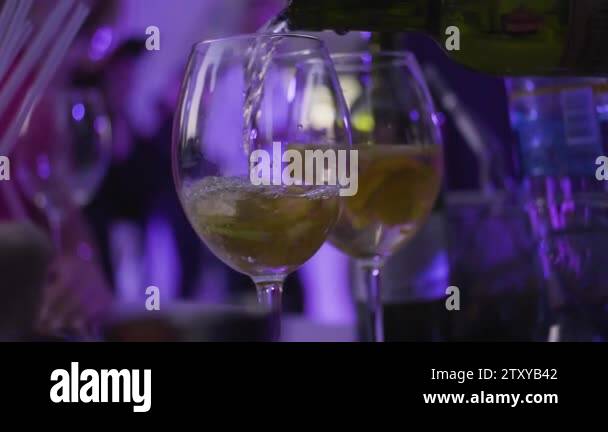 Close-up of wine glass pour white wine in nightclub. Frame. Pouring ...