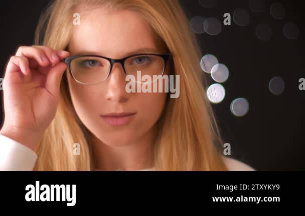 Relaxed blonde caucasian girl in glasses with smart look , touching her ...
