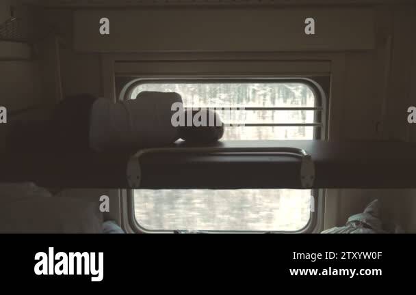 Boy on the train lying on the top shelf in a second-class carriage and ...