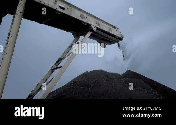 An overview of a coal falling from the belt conveyor at the coal mine ...