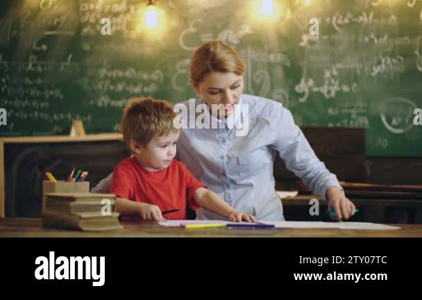 Teacher teaching school kid in classroom at school. Teacher in ...