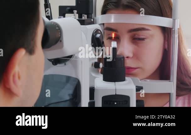 Ophthalmology treatment - a young woman with pink lips checking her ...