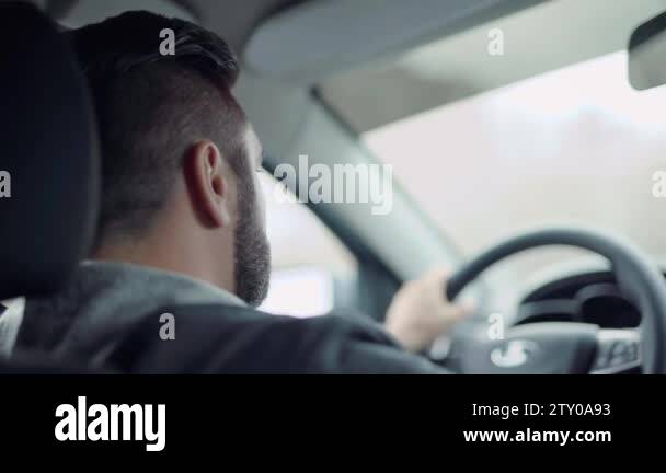 a man with a beard behind the wheel of a car. Low-cost cars are now ...