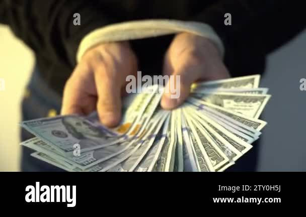 male hand bound with the rope holding pile of money american dollar ...