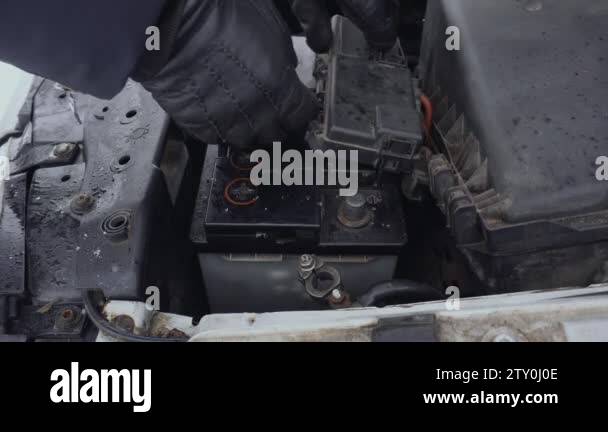 Man removes Discharged automotive battery from car to fix or repair in ...