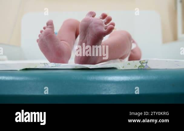 Newborn baby boy lying on back. Baby is kicking and stretching legs ...
