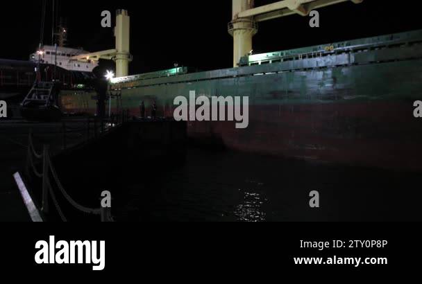 Night mooring of the cargo ship to the quay of the coal terminal. Port ...
