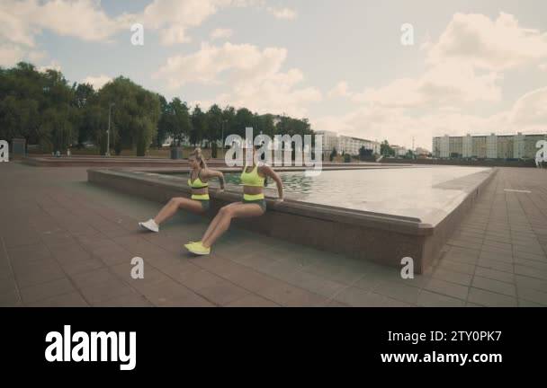 Two young women in sports clothing doing triceps exercise with slide ...