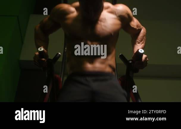 Handsome athletic men pumping up muscles push-ups on uneven bars ...